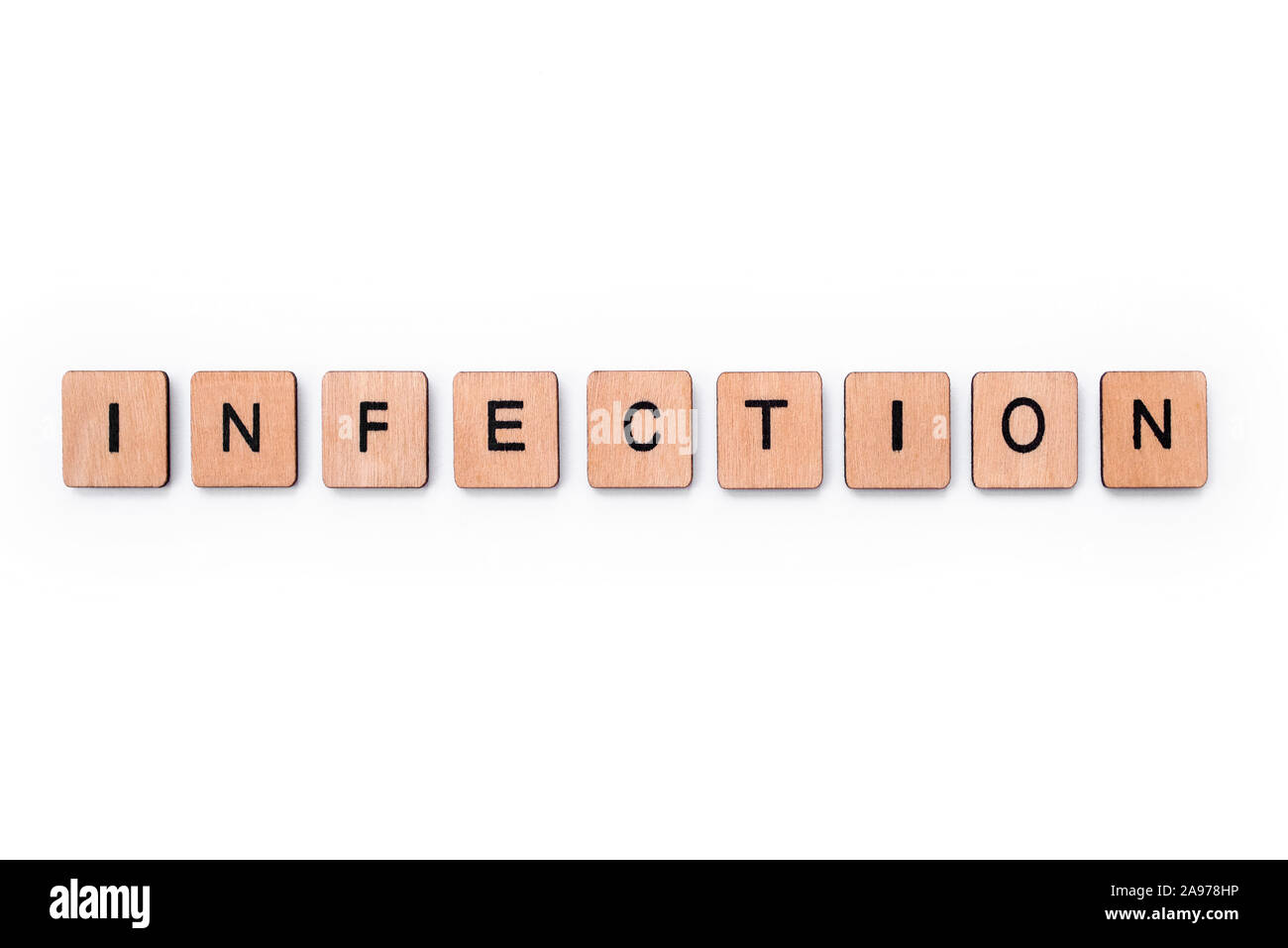 The word INFECTION, spelt with wooden letter tiles over a white ...