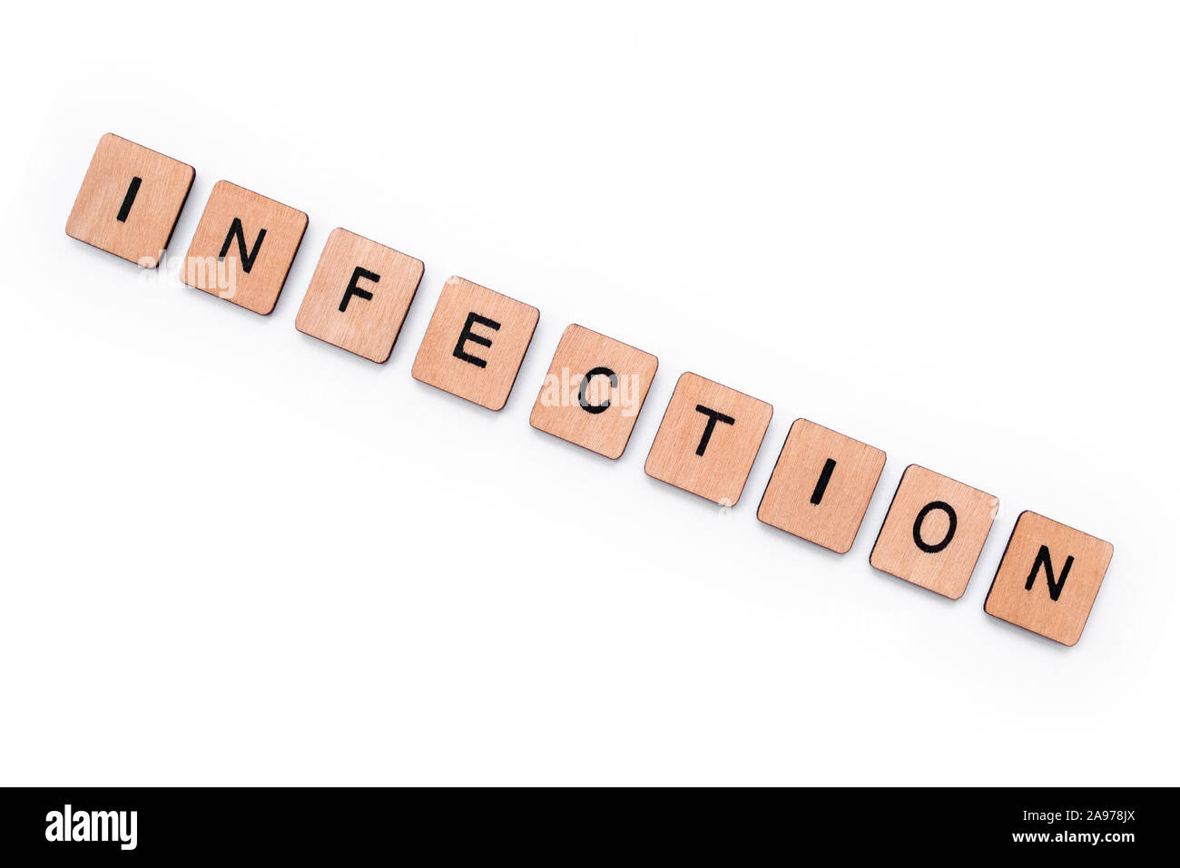 The word INFECTION, spelt with wooden letter tiles over a white ...