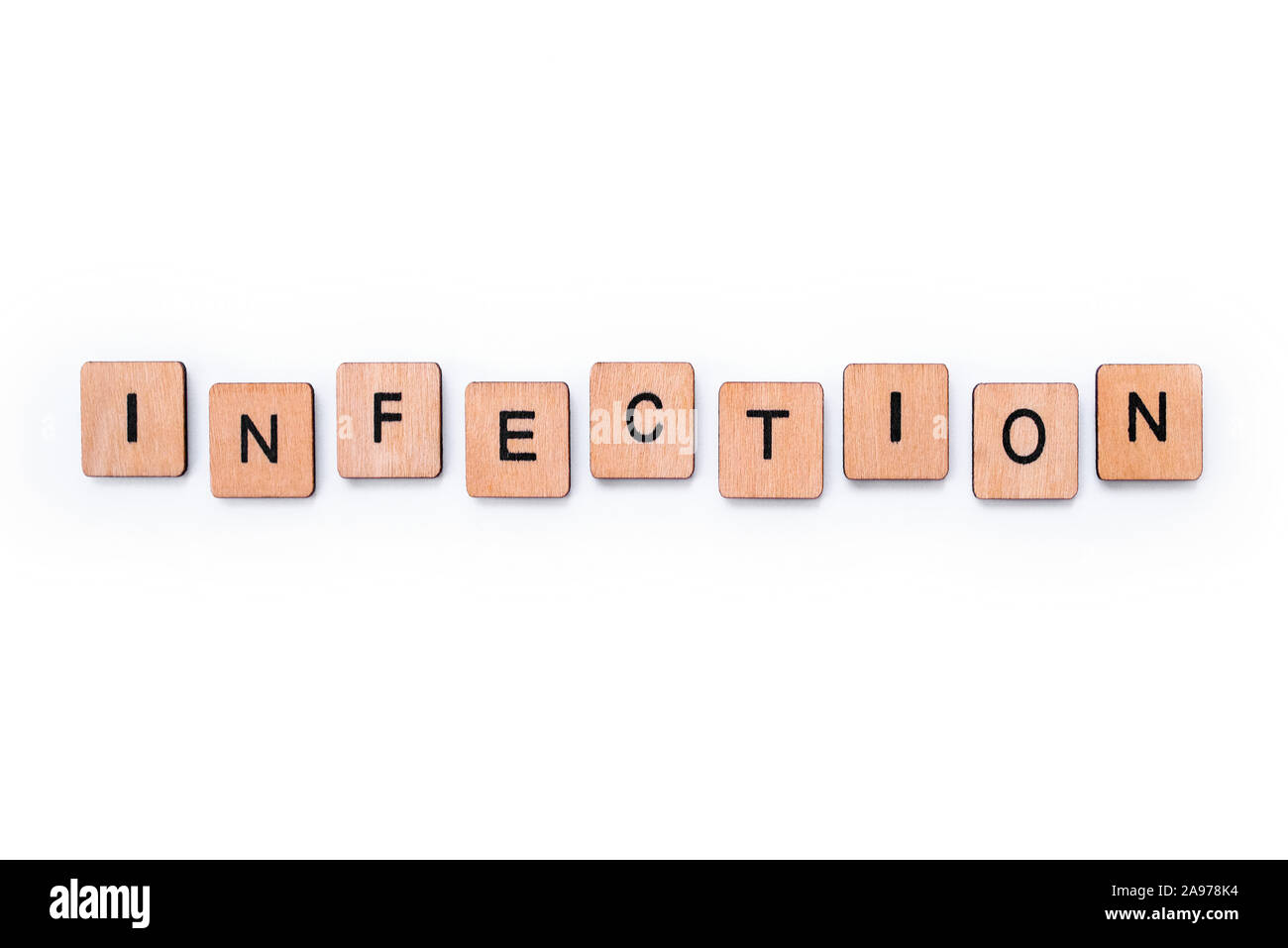 The word INFECTION, spelt with wooden letter tiles over a white ...