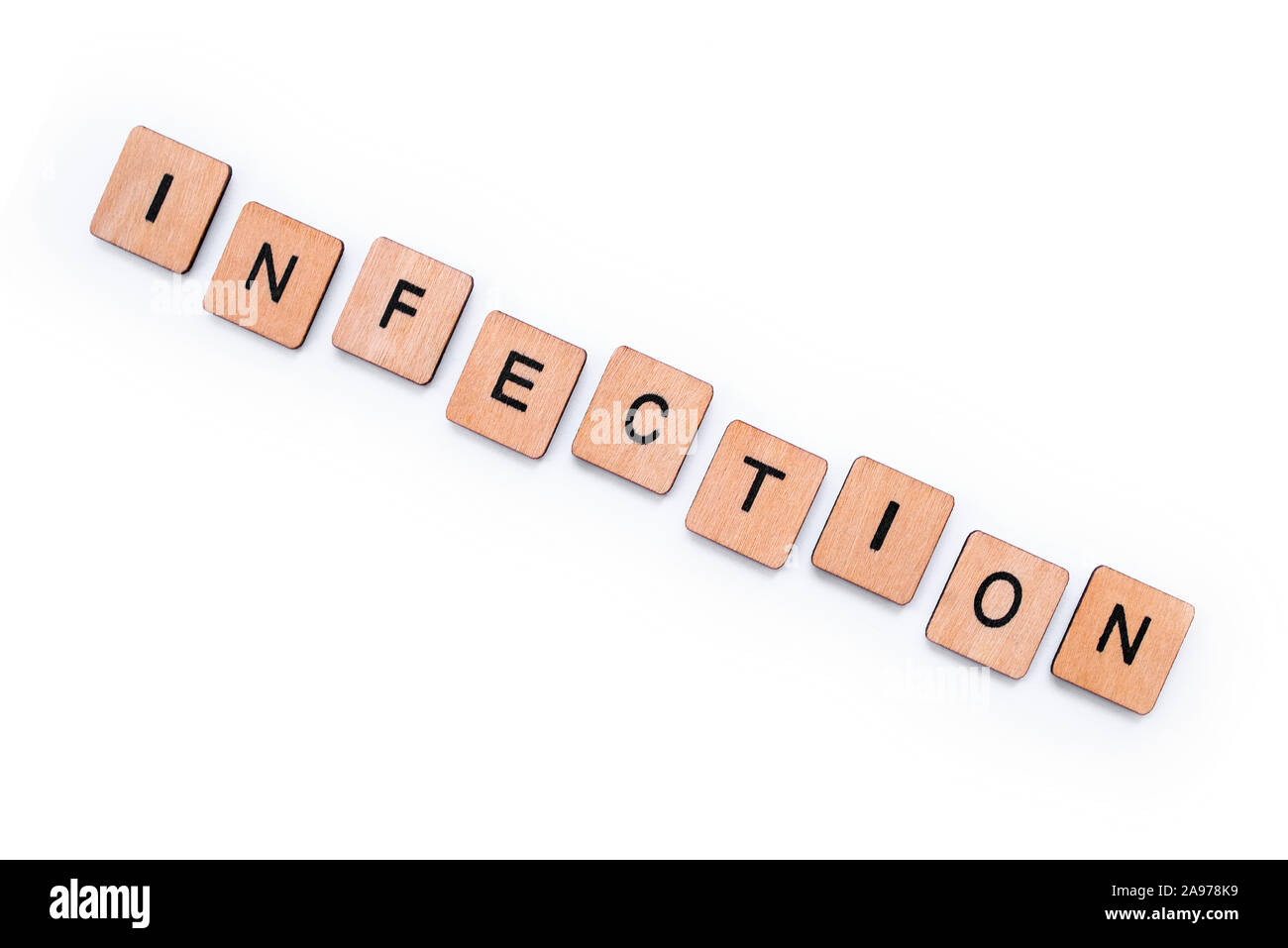 The word INFECTION, spelt with wooden letter tiles over a white ...
