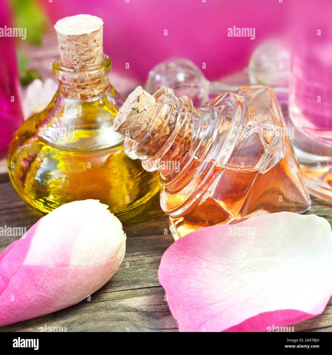 Wellness rose oil and wooden background Stock Photo - Alamy