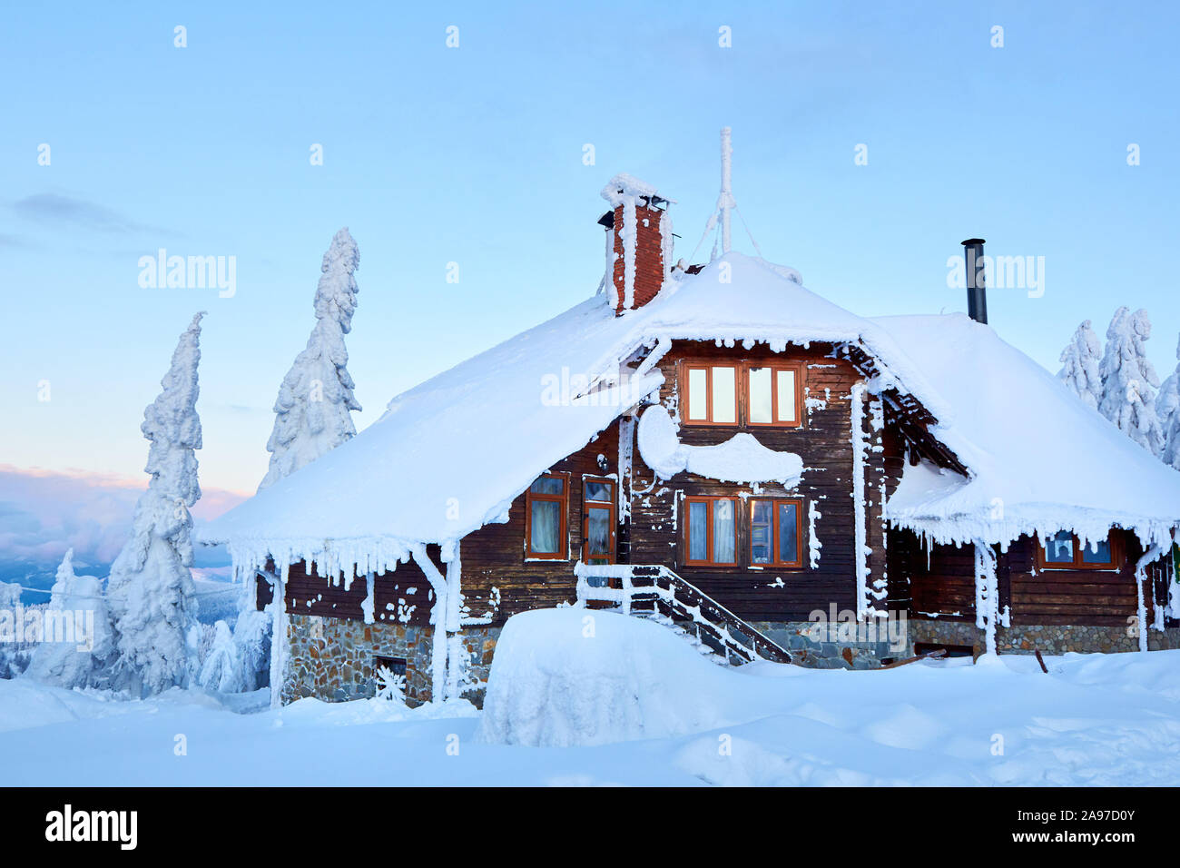 Christmas wooden mansion in mountains on snowfall winter day. Cozy ...