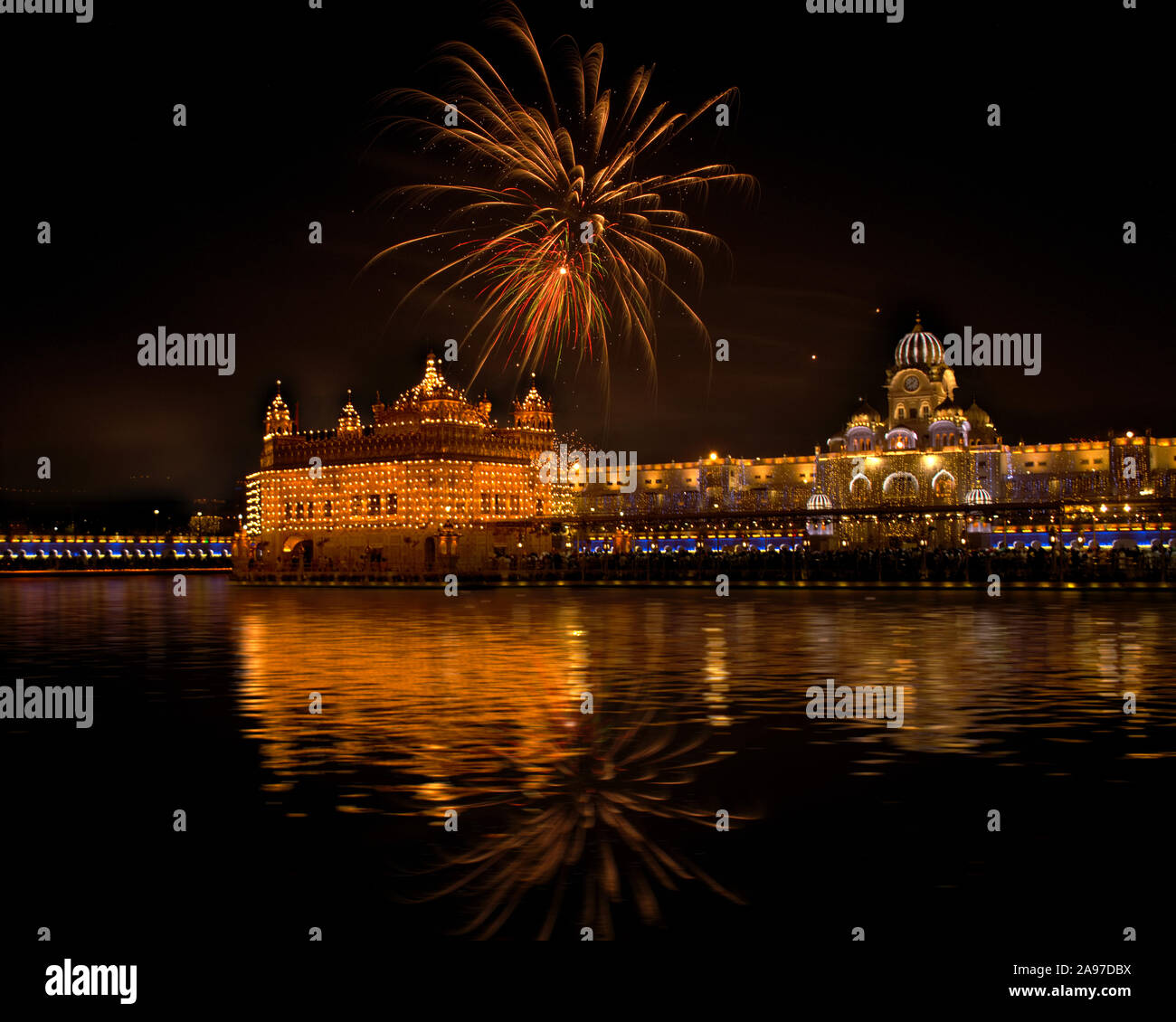 Fireworks over a beautiful temple with a serene water body around on ...