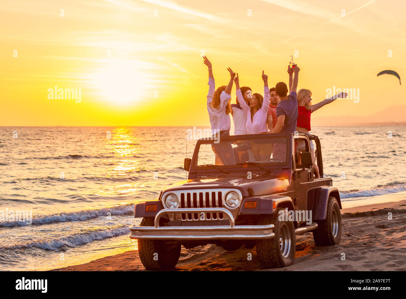 Young group having fun on the beach drink beer and dancing in a ...