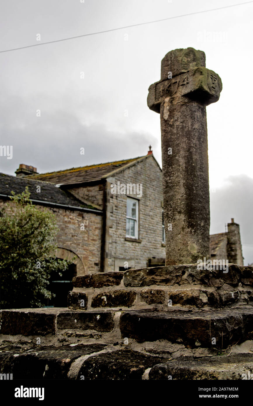 The ancient market cross, dating from 1674, in Carperby, Leyburn ...