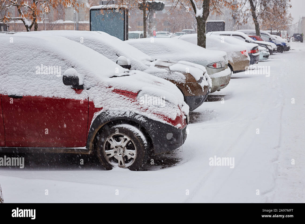 a street with houses and cars are covered with snow in wintertime Stock ...