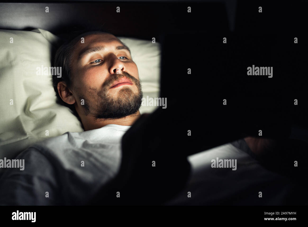 Young man asleep dark bed hi-res stock photography and images - Alamy