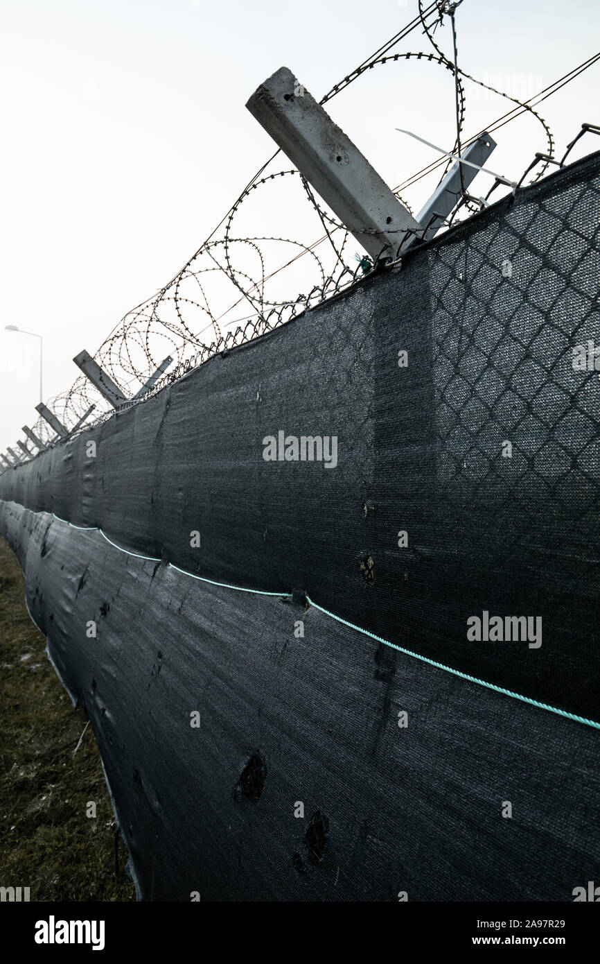 Barbed wire on a fence in a foggy day. Barbed wire fencing from the ...