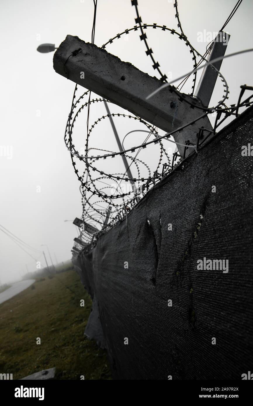 Barbed wire on a fence in a foggy day. Barbed wire fencing from the ...