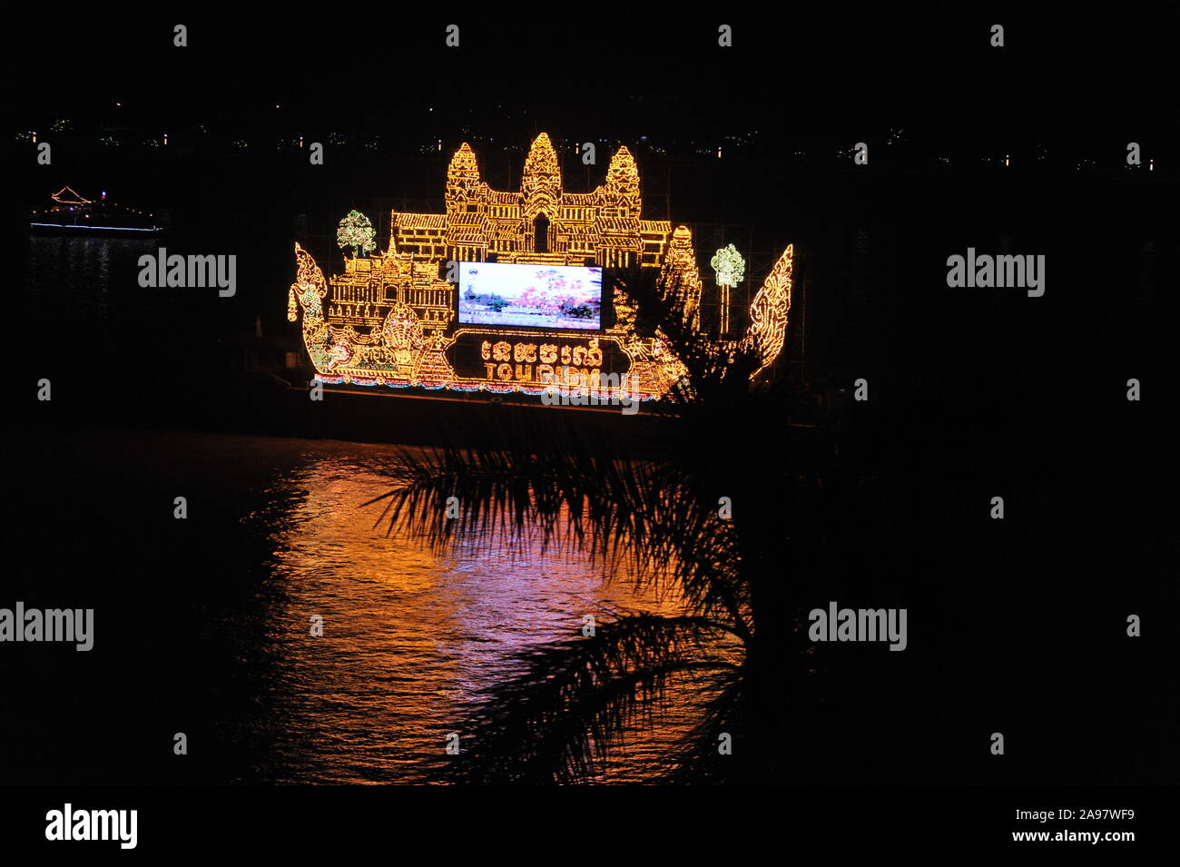 an Illuminated float / barge casts its reflection on the Tonle Sap ...