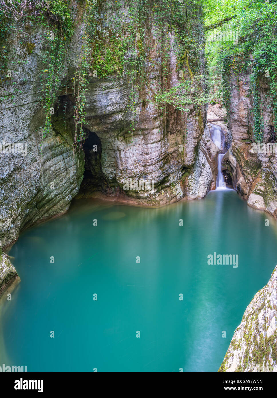 A mountain river in a stone gorge cascades into a clear lake. Mountain ...