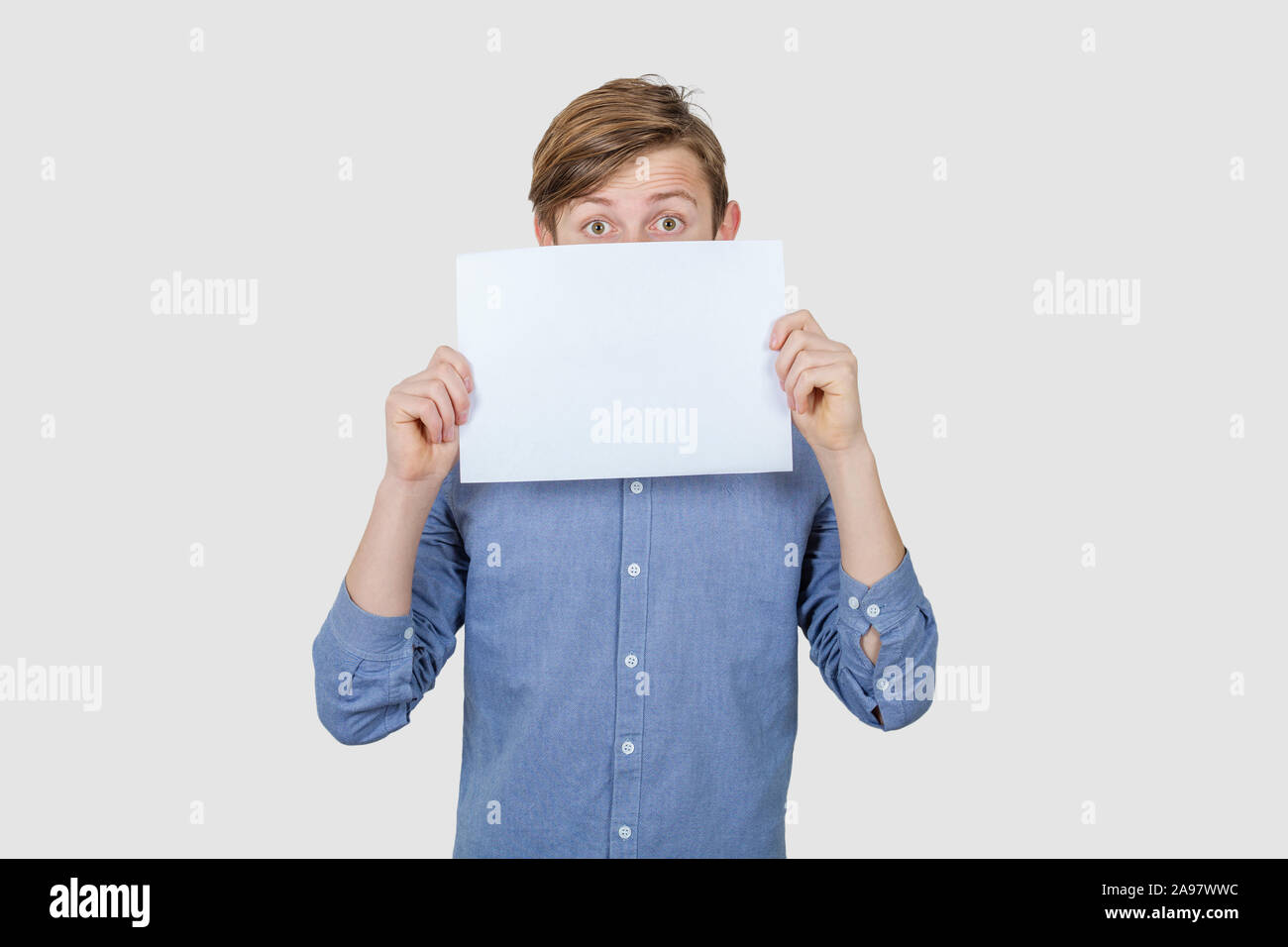 Shocked Teenage boy covering his face with a empty white paper over ...