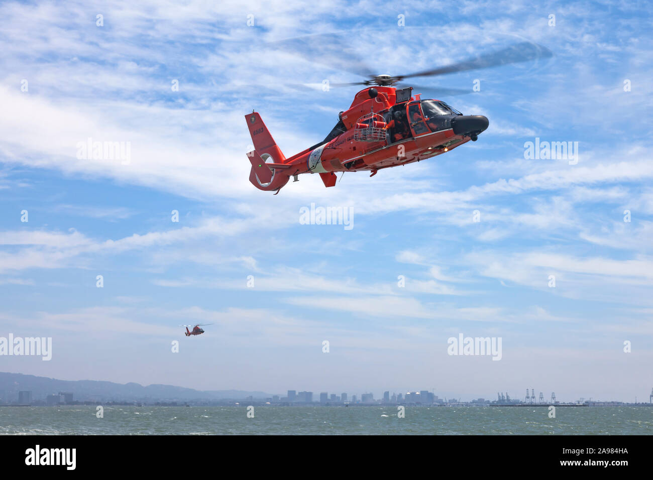 A pair of US Coast Gaurd MH-65 Dolphin helicopters hover over San ...