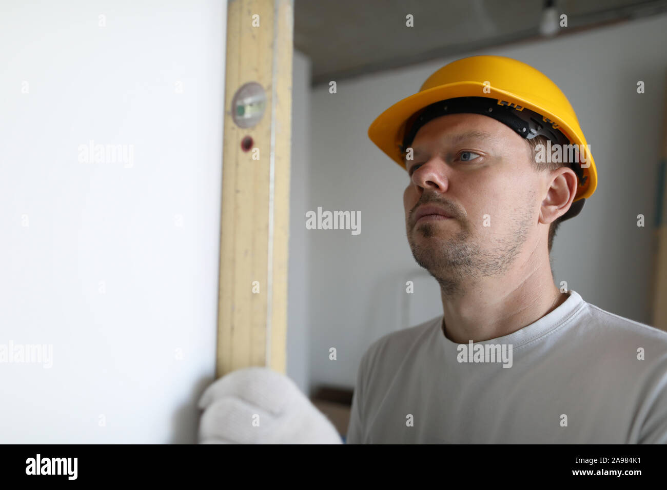 Worker measuring wall in apartment Stock Photo - Alamy