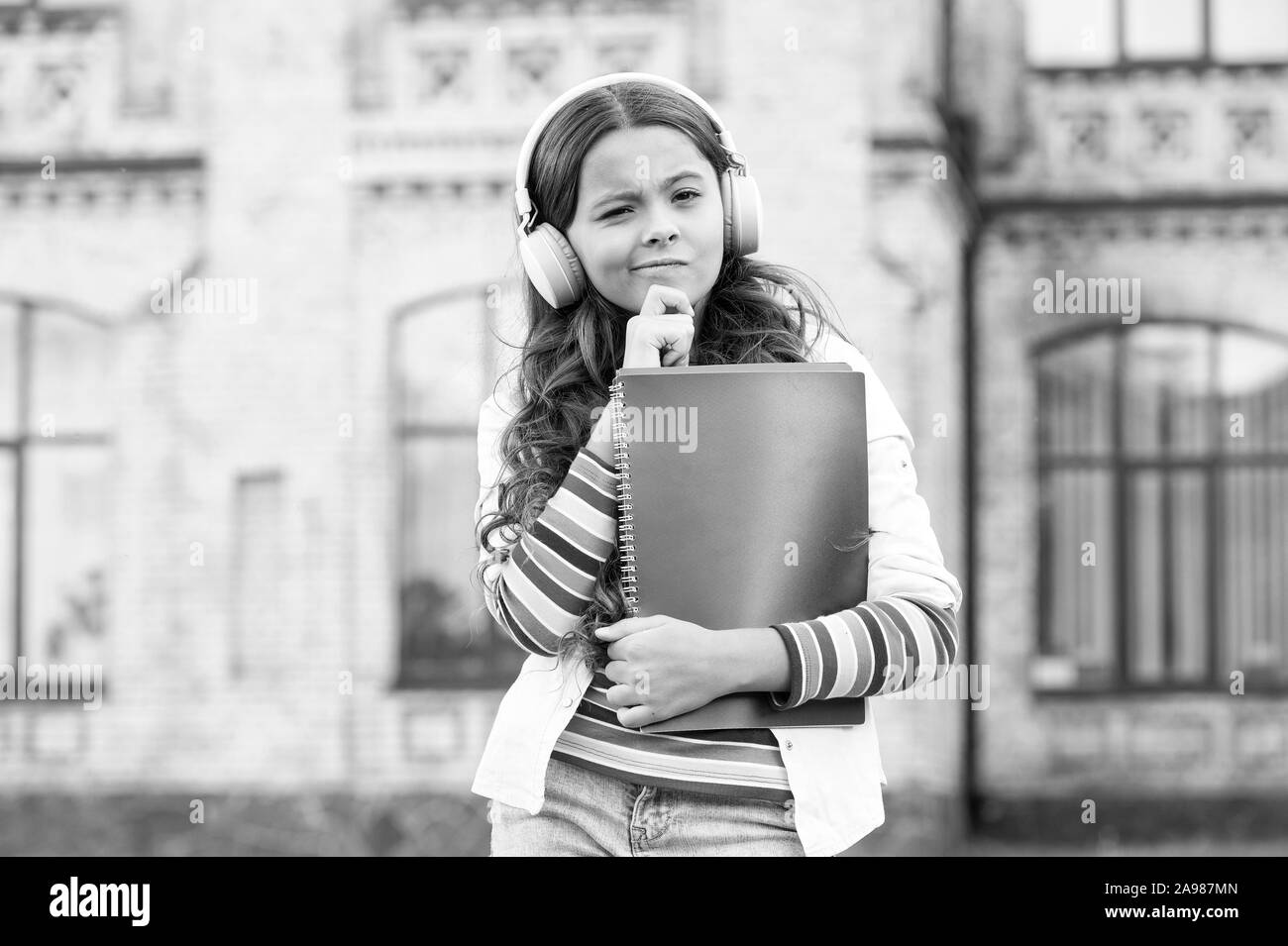 Developing effective listening skills. Serious little girl listening to ...