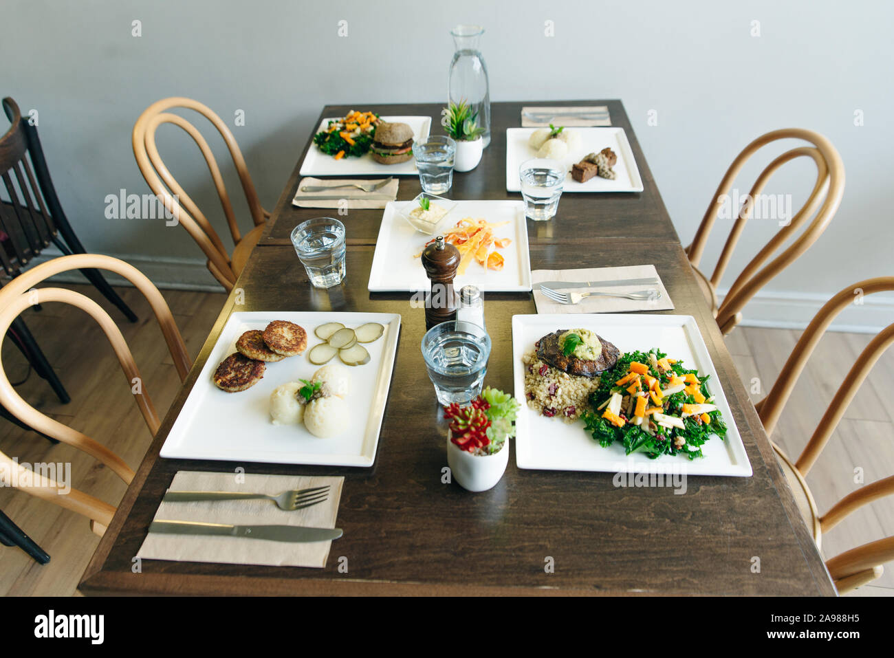 Wooden table set with organic and colorful food for four people Stock ...