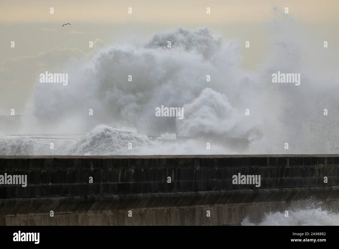 Big splash from a stormy sea wave breaking over piers. Douro river ...