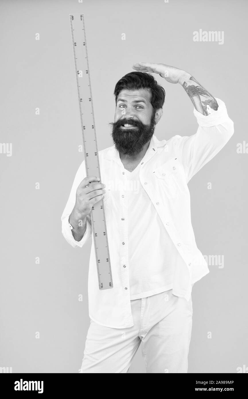 Measuring his height with ruler. School teacher or university student ...