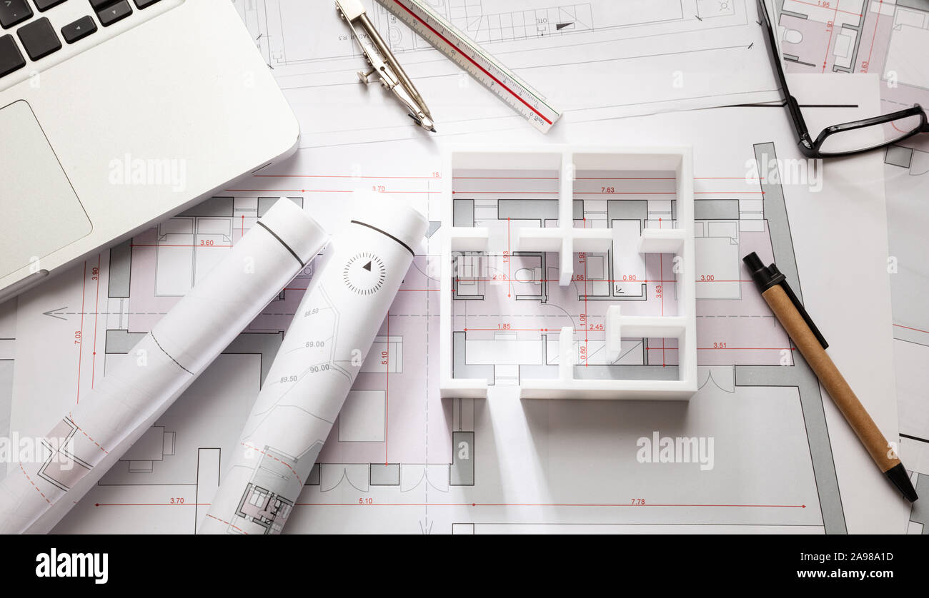 Architect engineer office desk. Blueprint plans and house model ...