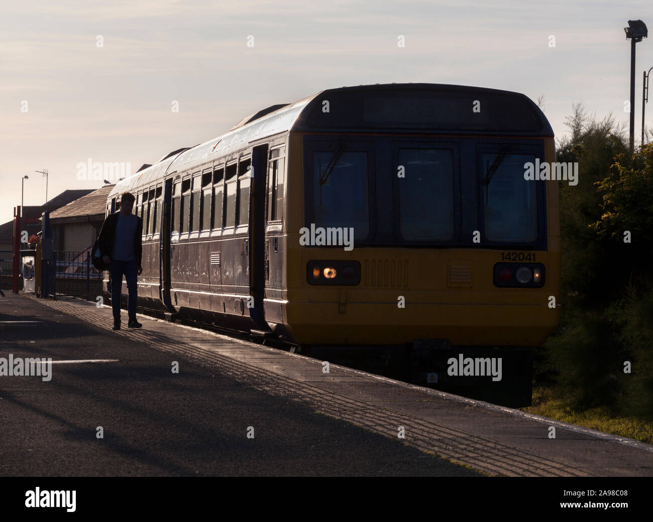 Passenger boarding a Arriva Northern rail class 142 pacer train at Morecambe railway station ...