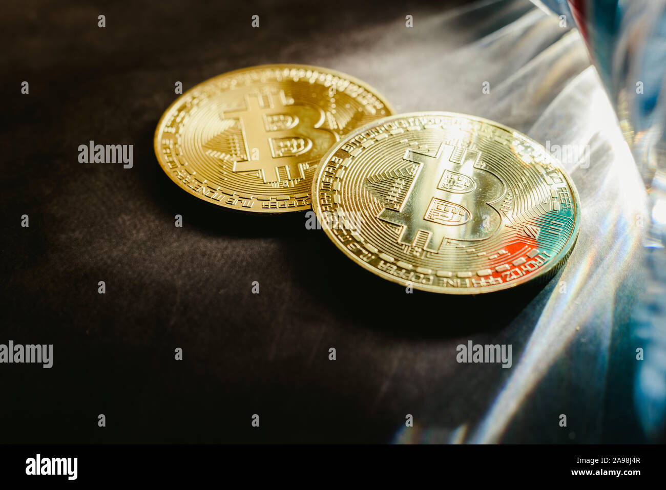 Bitcoin physical coins illuminated by light rays with dark background ...