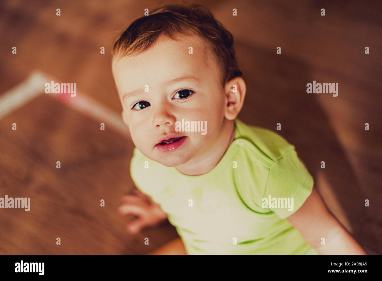Face of a baby seen from above looking at the camera with attention ...