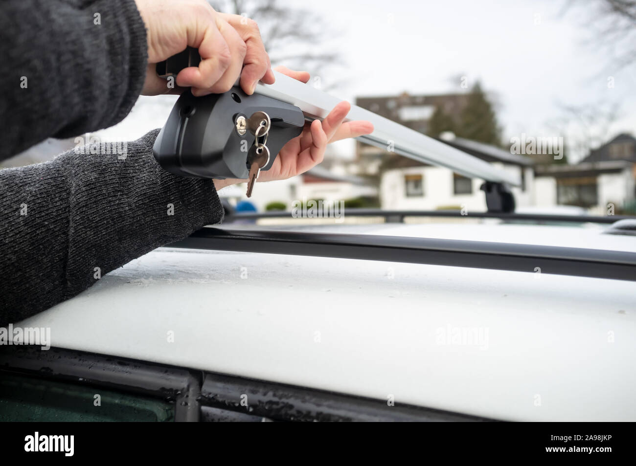 Man installs attachments with a lock and keys for the trunk or cargo ...
