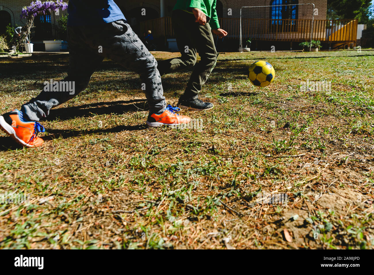 Children chasing an old soccer ball in a friendly match in summer Stock ...