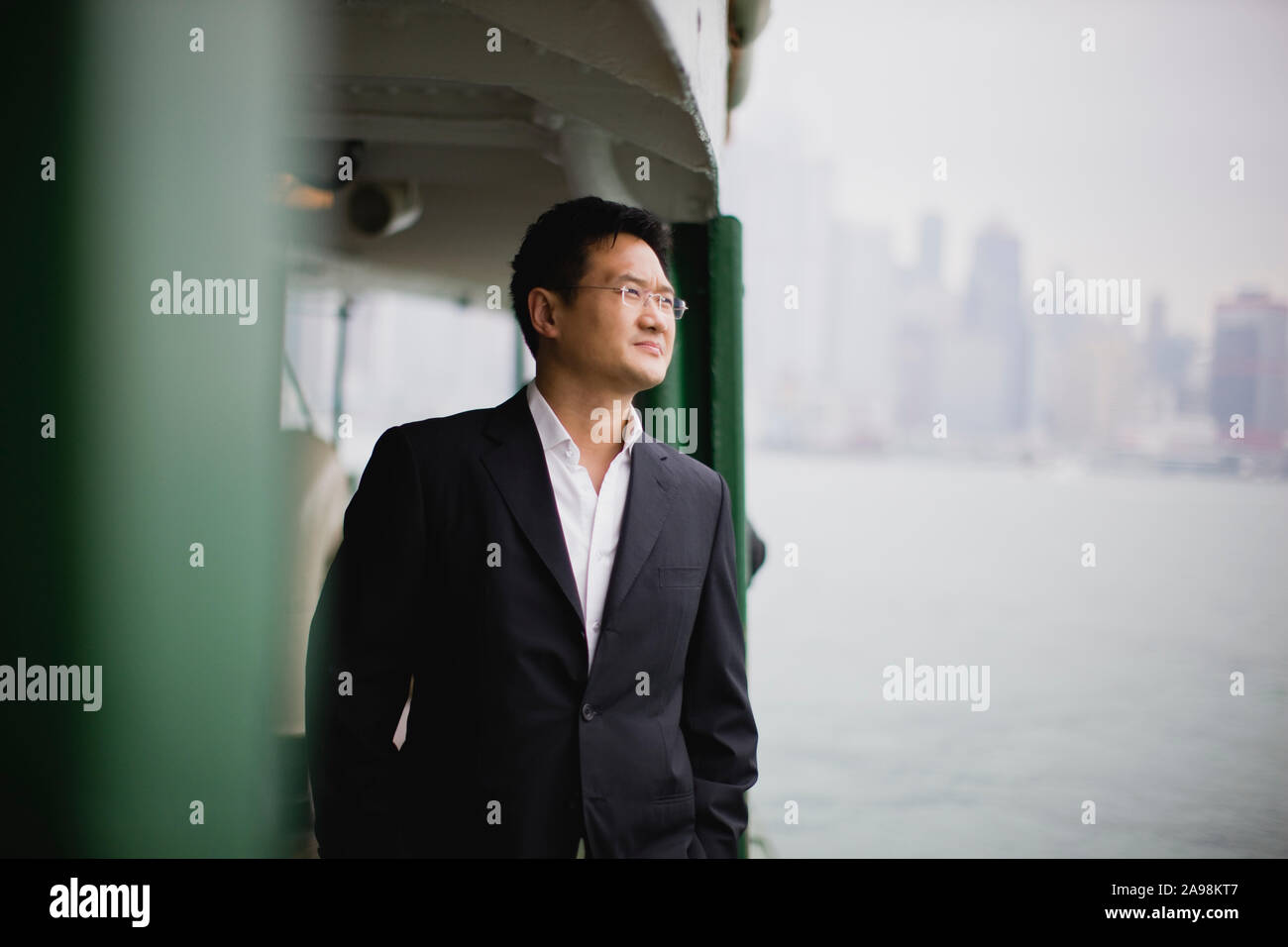 Mid-adult businessman standing on a boat in an inner city harbor Stock ...