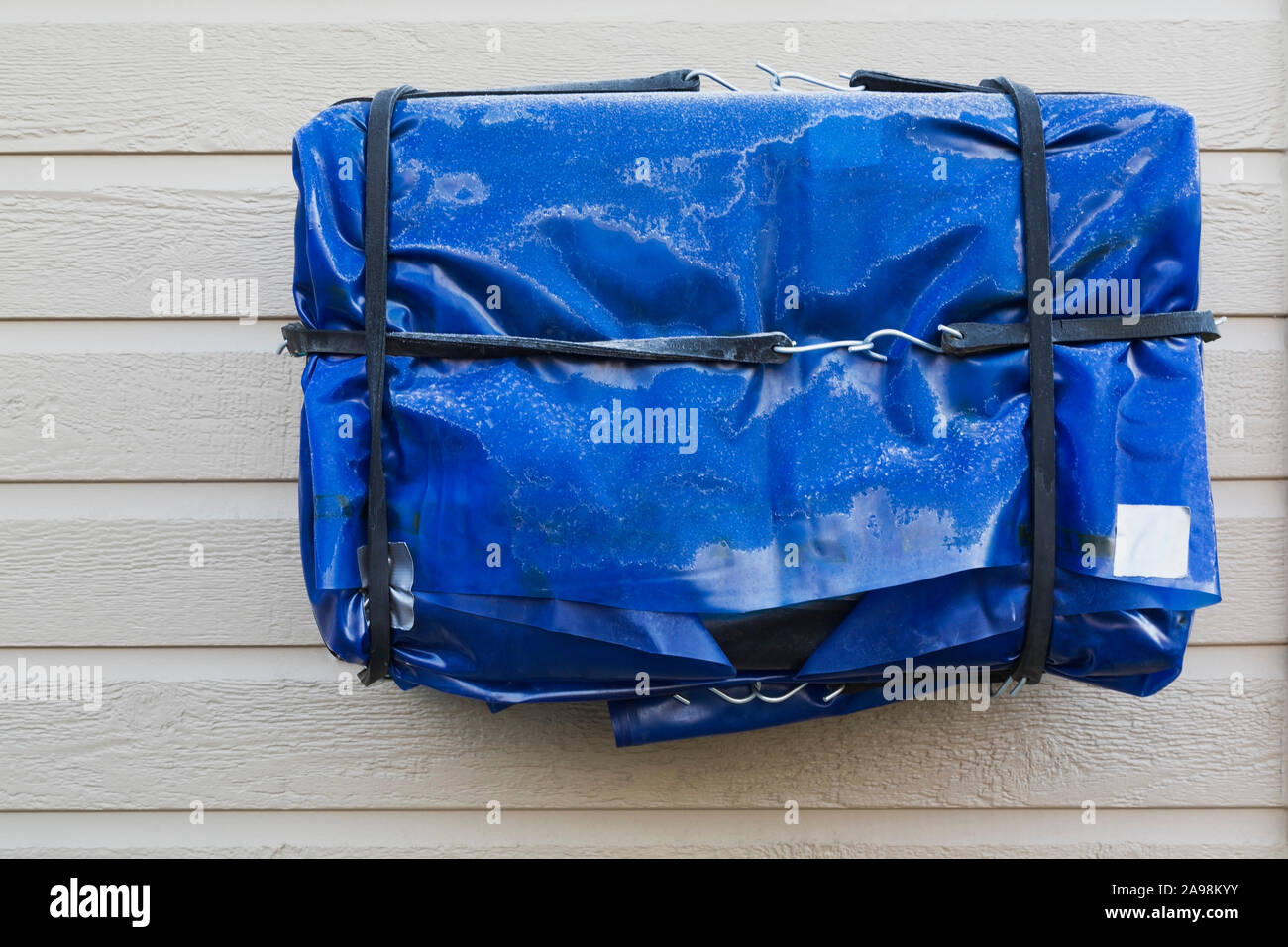 Through the wall air conditioning unit wrapped with blue polyethylene ...