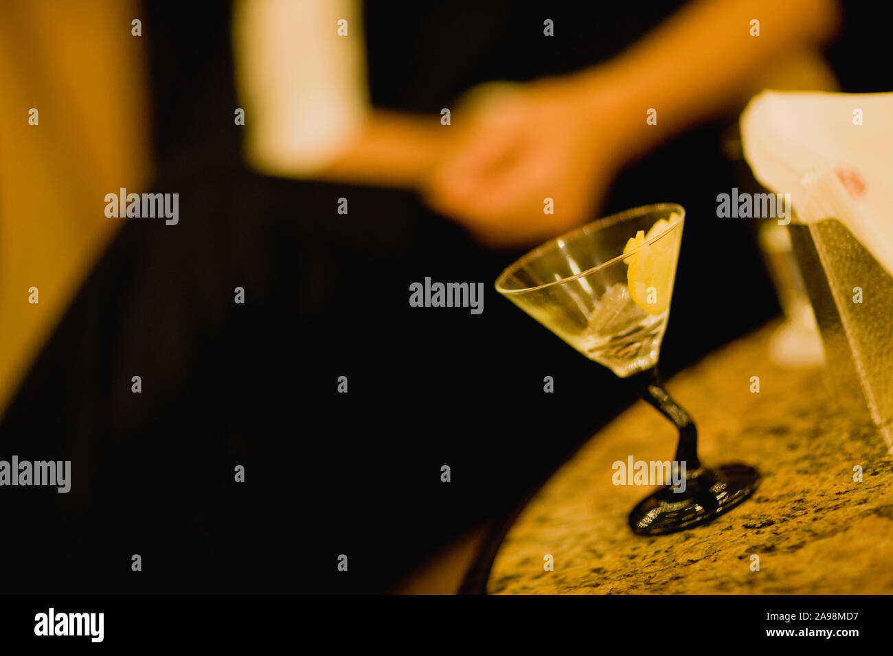 Empty cocktail glass sitting on a table with a slice of lemon inside ...