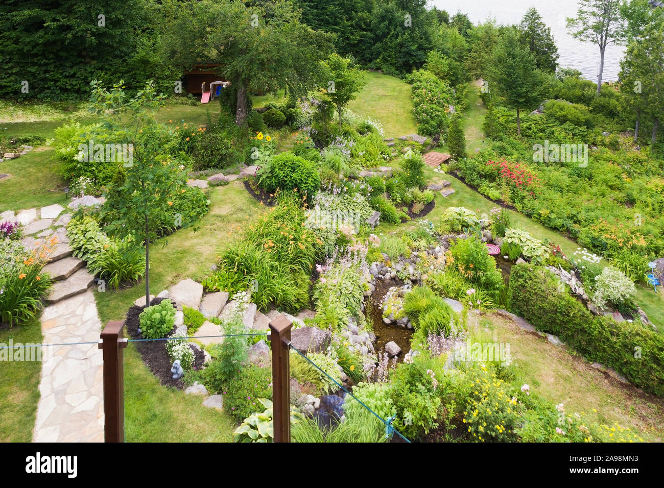 Top view of sloped residential backyard garden with rock edged stream ...