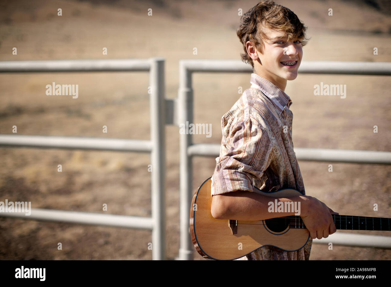 Portrait of a smiling teenage boy holding an acoustic guitar Stock ...