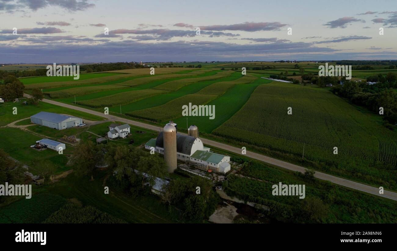 Aerial view of rural farmstead with rolling countryside at sunset with ...