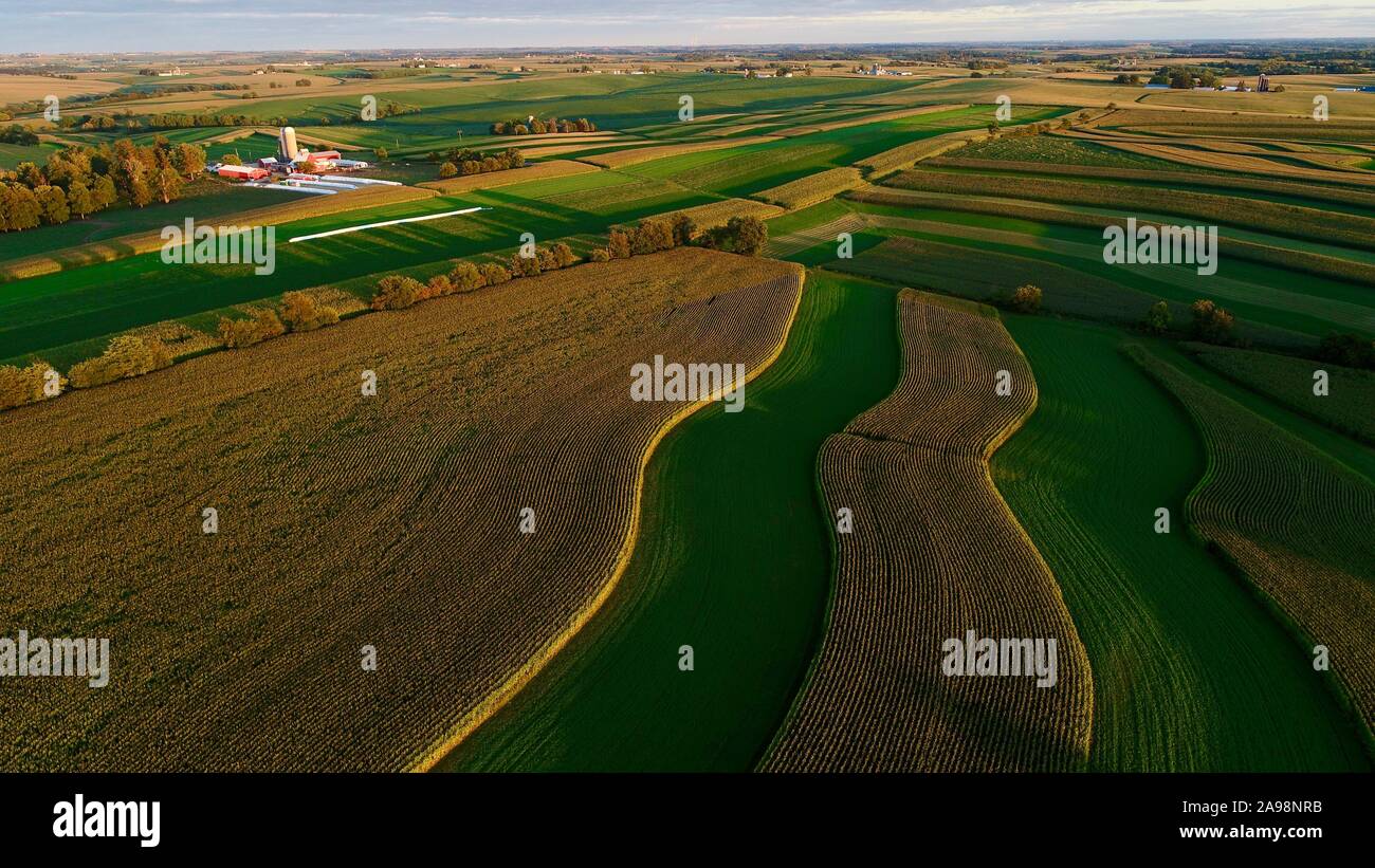 Aerial view of rural farmstead with rolling countryside at sunset with ...