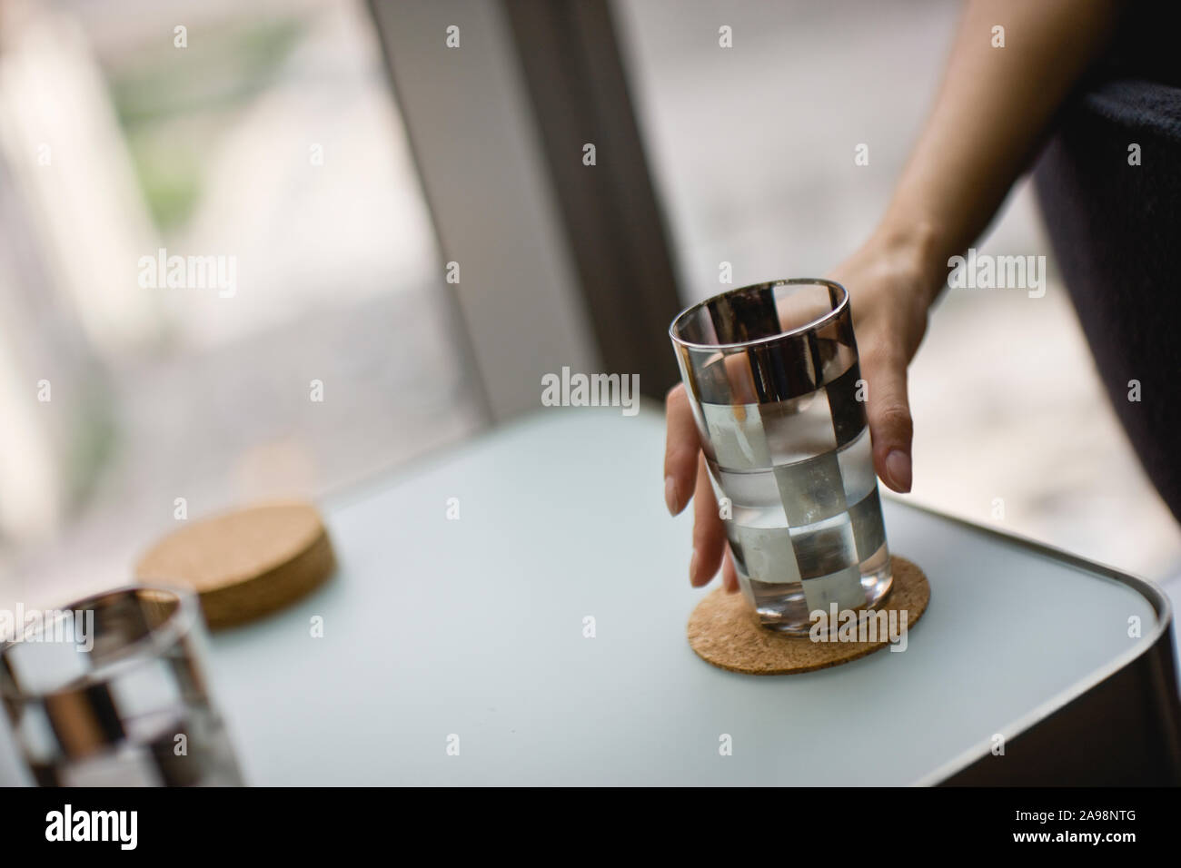 Water glass held by a woman Stock Photo - Alamy
