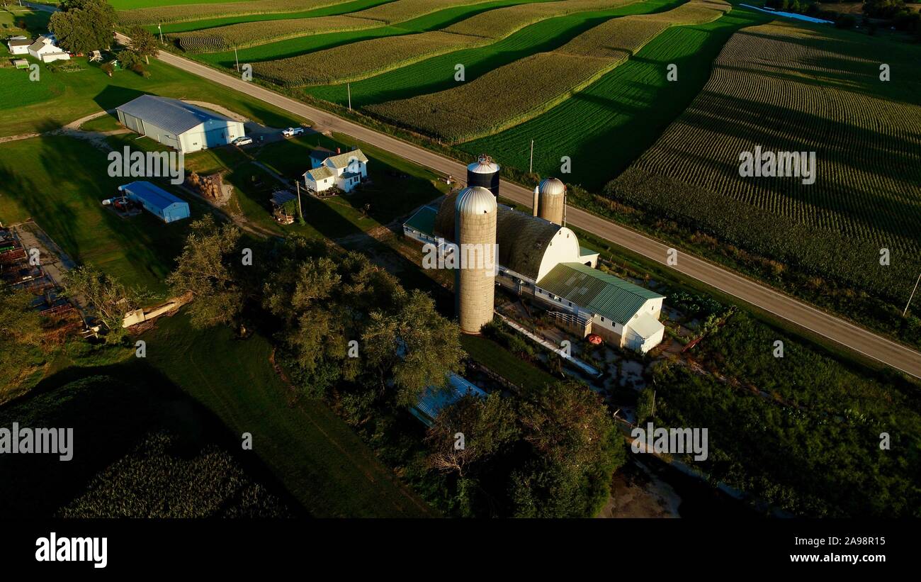 Aerial view of rural farmstead with rolling countryside at sunset with ...