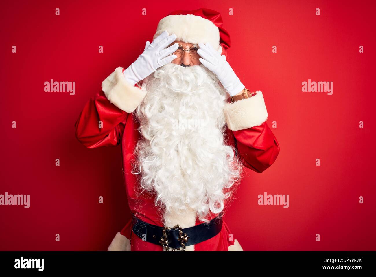 Middle age handsome man wearing Santa costume standing over isolated ...