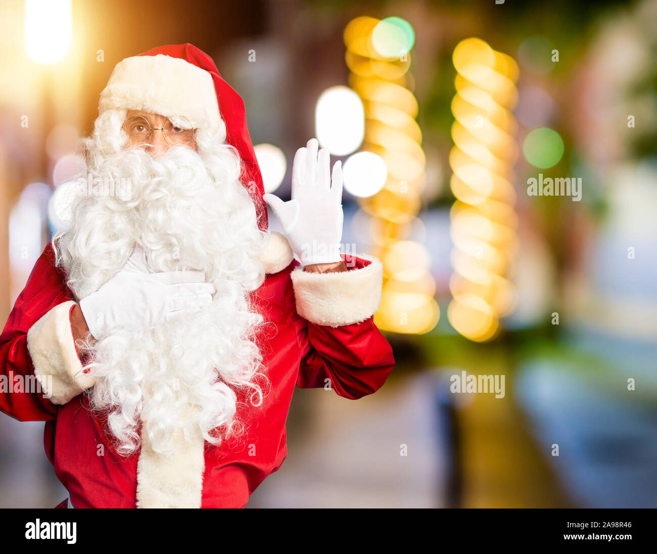 Middle age handsome man wearing Santa Claus costume and beard standing ...