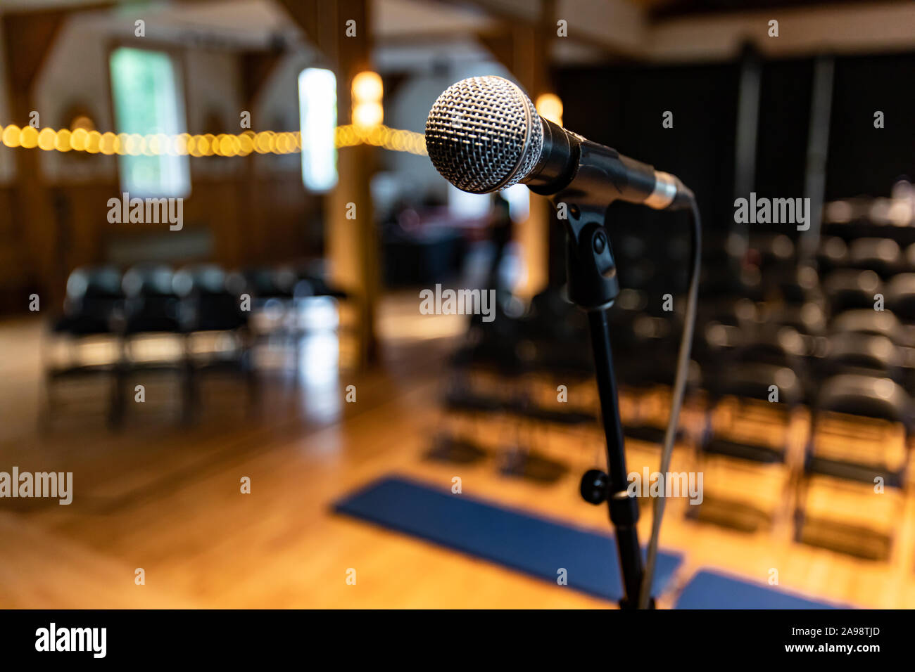 Close up photo of a microphone standing on stage in an empty music hall ...