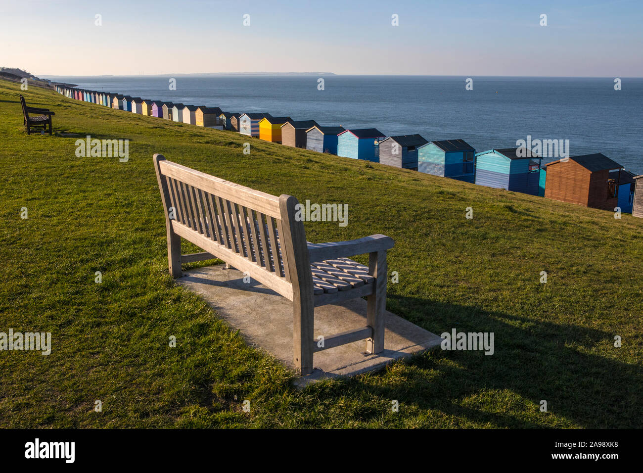 Benches and beach huts along the seafront in the coastal town of ...