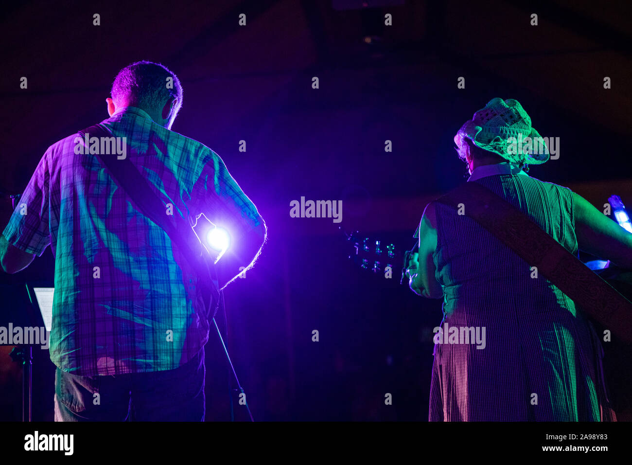 Behind view photo of two musicians playing their instruments on stage ...