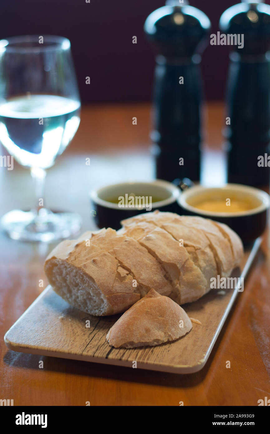 Handmade Bread Loaf and olive oil and Miso butter on a wooden platter ...
