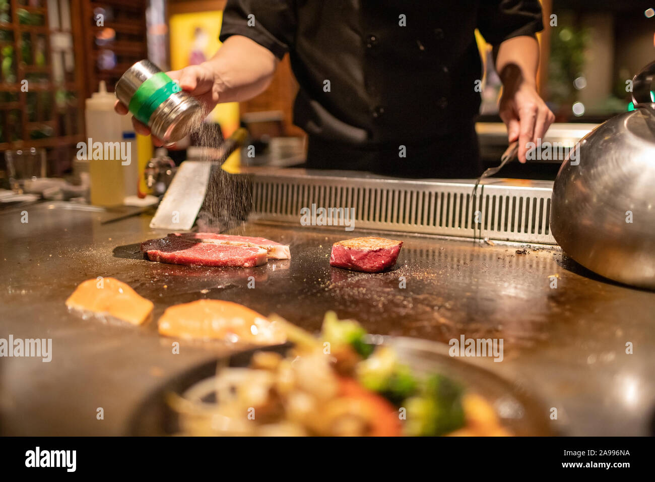 Teppanyaki chef cooking Japanese Wagyu beef and filet mignon steak on ...