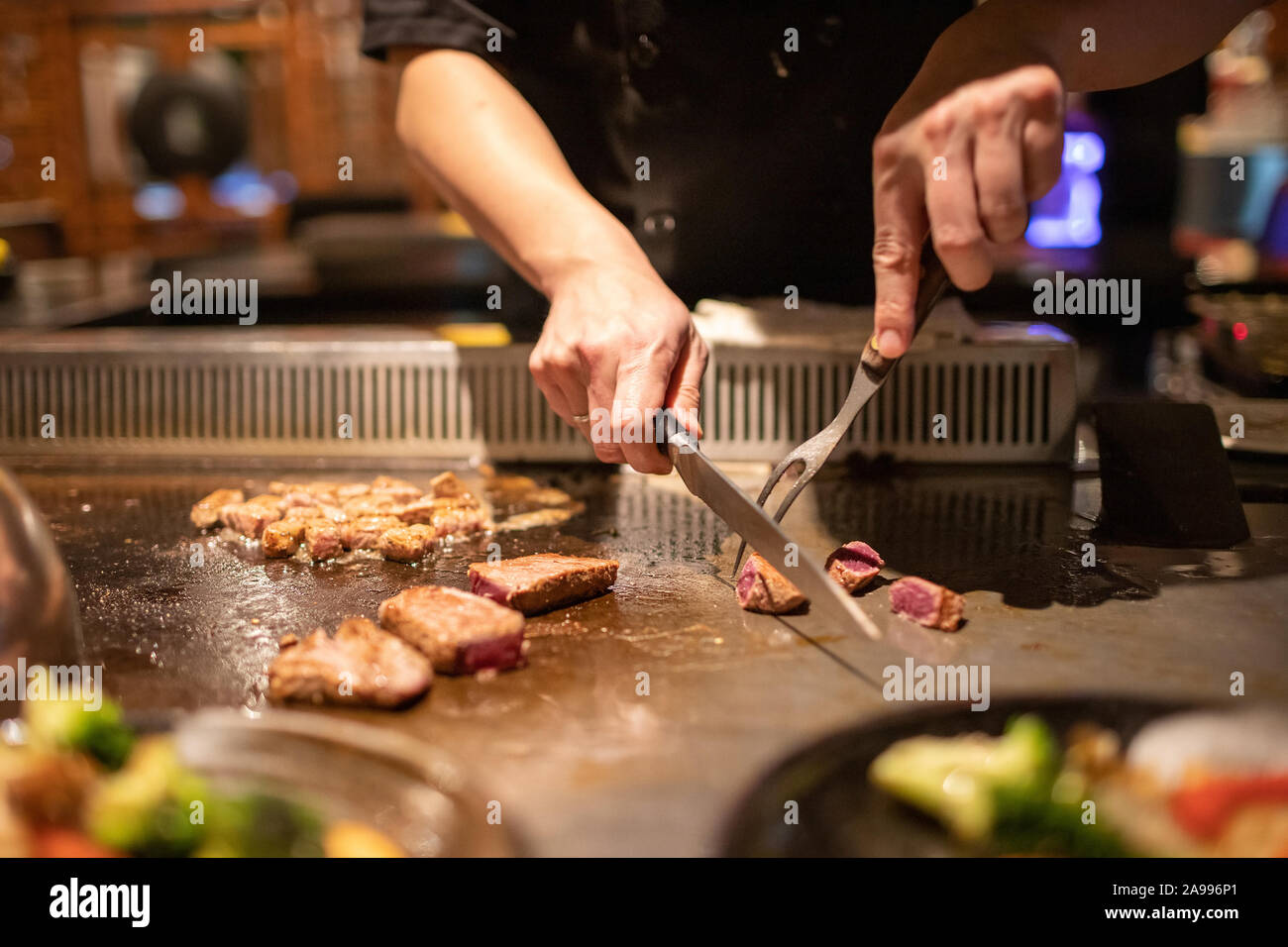 Teppanyaki chef cooking Japanese Wagyu beef and filet mignon steak on ...