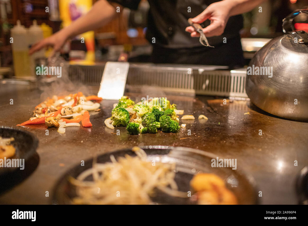 Teppanyaki chef preparing Japanese cuisine on hot metal plate by ...