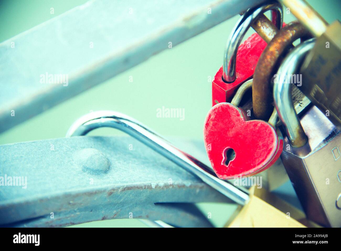 Close up of heartshaped love padlock locked on the rail of a bridge - a ...