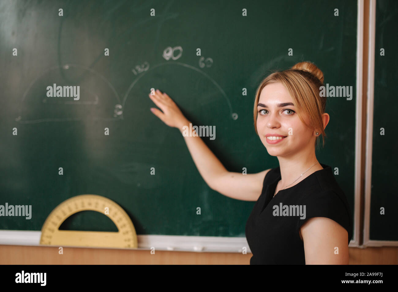 Teacher help girl by the blackboard. Young female teacher study Stock ...