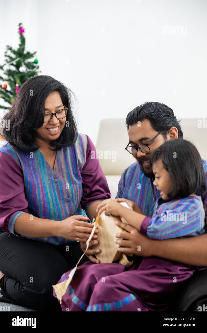 family with daughter open christmas gift together Stock Photo - Alamy