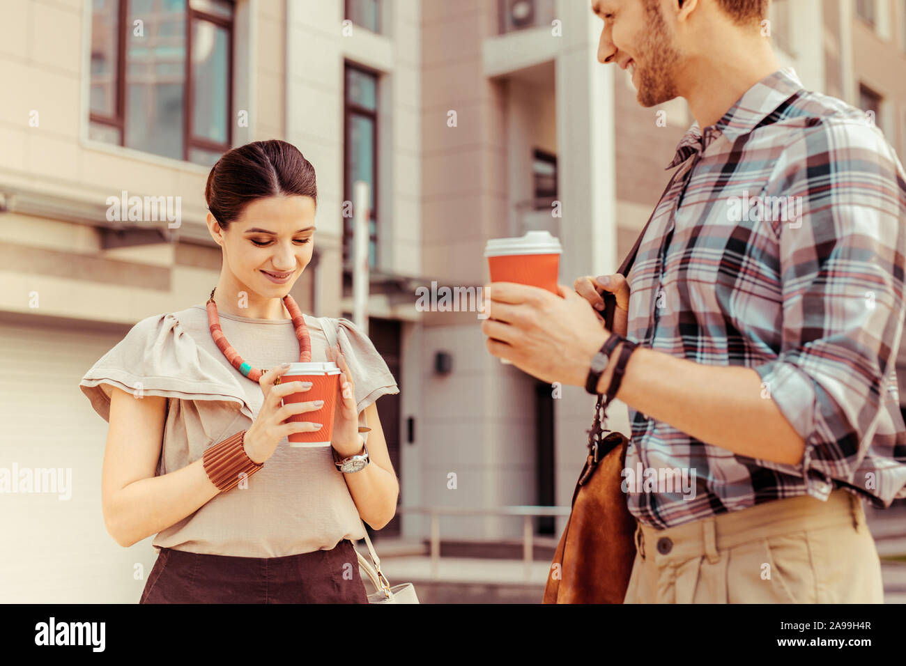Kind young female person staring at her paper cup Stock Photo - Alamy